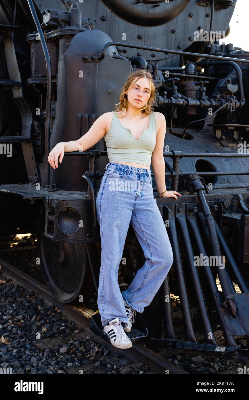 Teenage Girl in Trainyard Standing in Front of Old Black Steam Engine ...