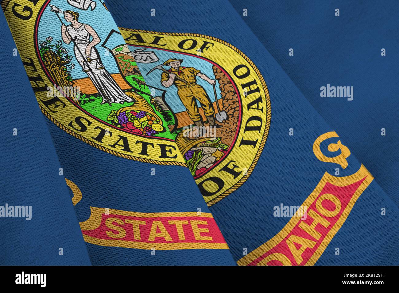 Idaho US state flag with big folds waving close up under the studio ...