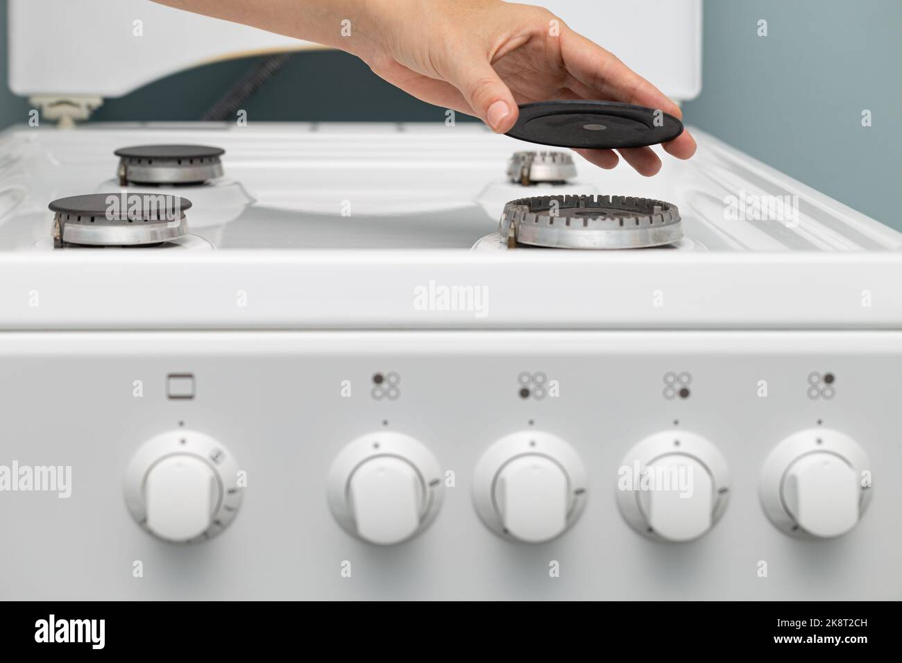 man washing a gas stove with a rag. hostess cleaning the kitchen. High ...