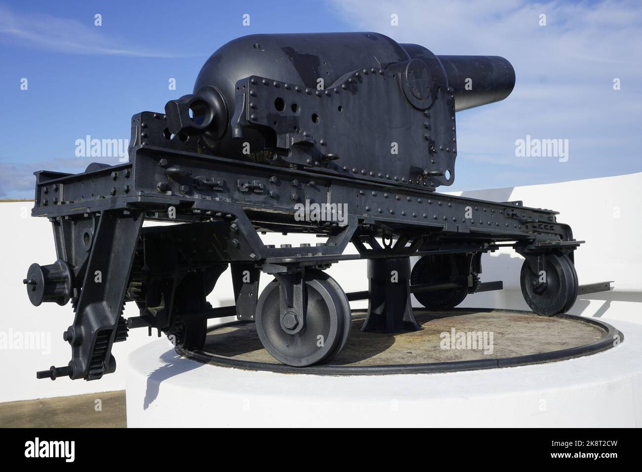 A black cannon on a white ground under a blue sky with clouds Stock ...