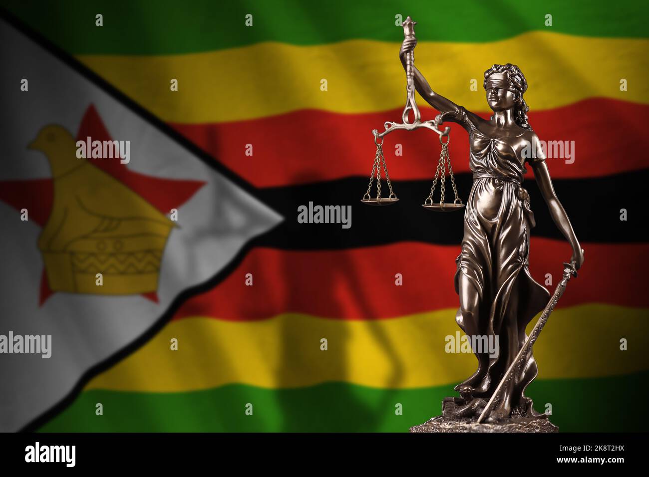 Zimbabwe flag with statue of lady justice and judicial scales in dark ...