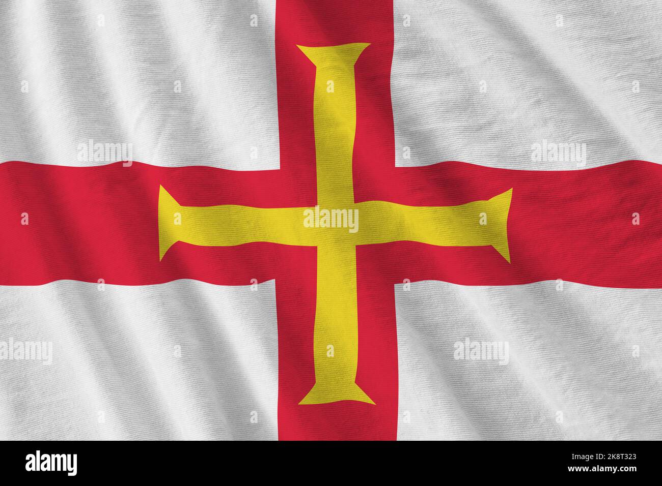 Guernsey flag with big folds waving close up under the studio light ...
