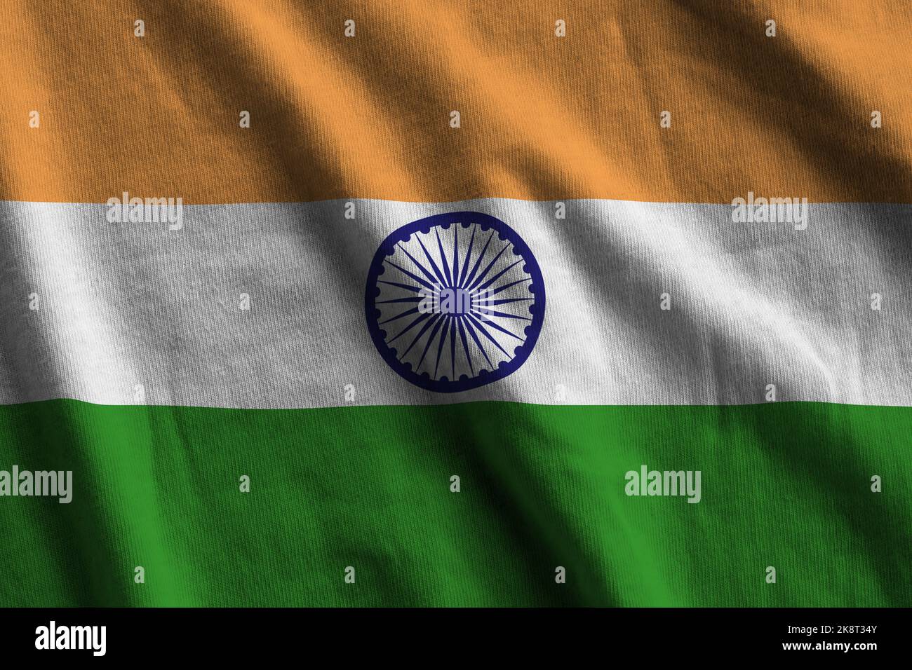 India flag with big folds waving close up under the studio light ...