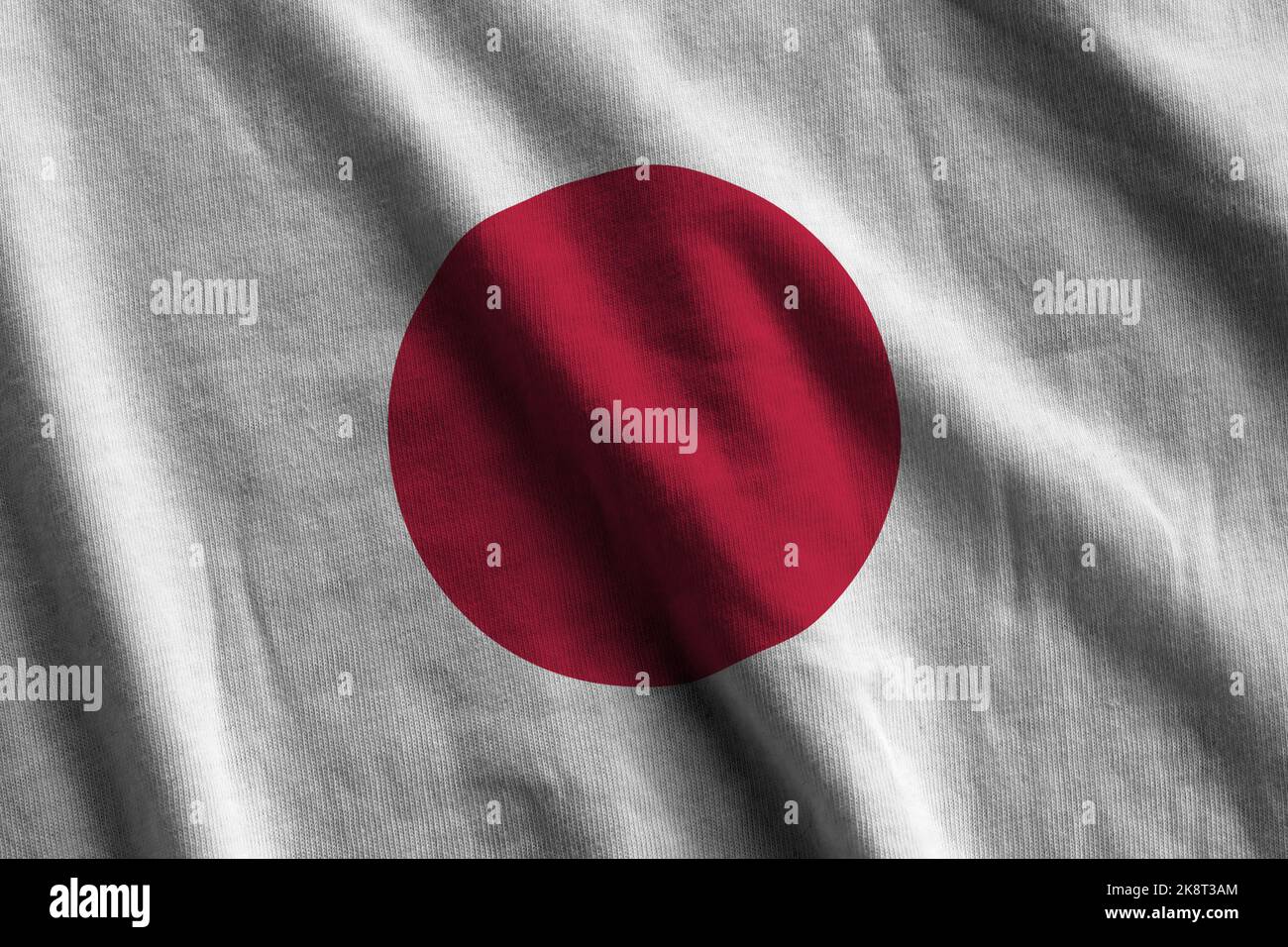 Japan flag with big folds waving close up under the studio light ...