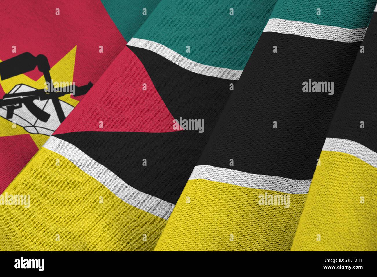 Mozambique flag with big folds waving close up under the studio light ...