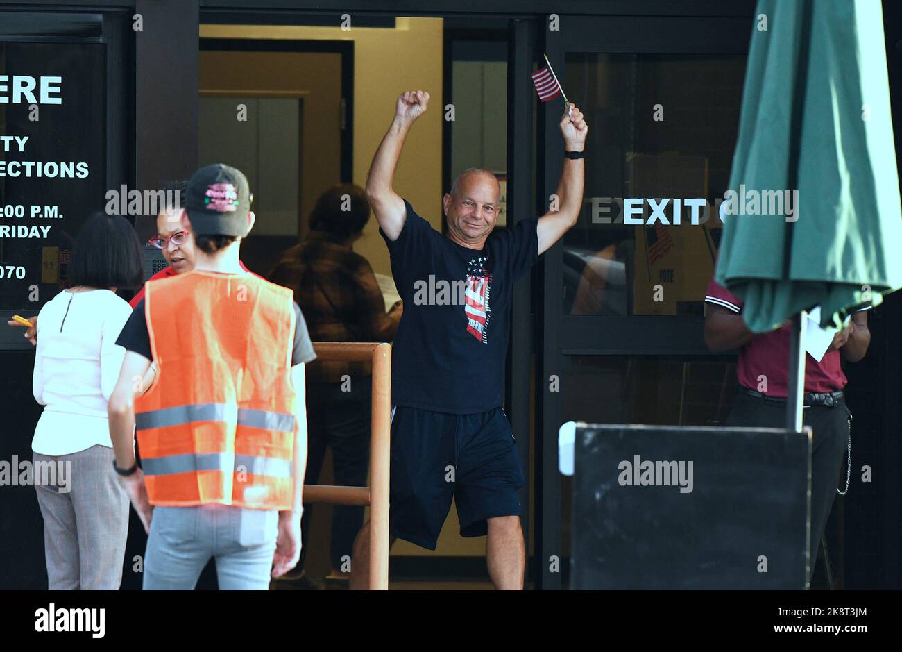 A man leaves the Orange County Supervisor of Elections Office waving an ...