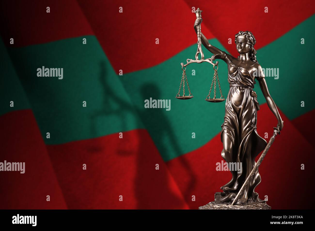 Transnistria flag with statue of lady justice and judicial scales in dark room. Concept of ...