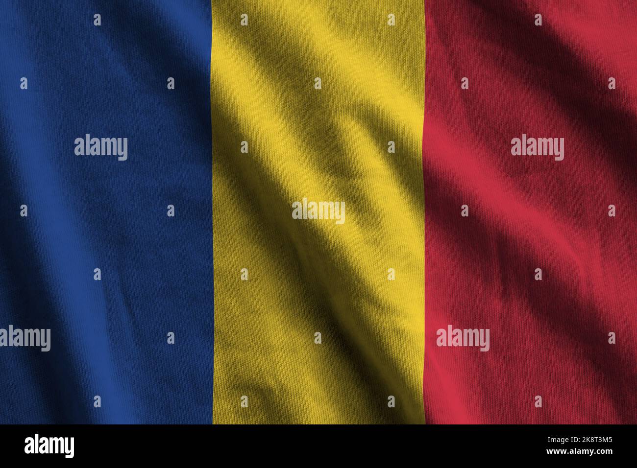 Romania flag with big folds waving close up under the studio light ...