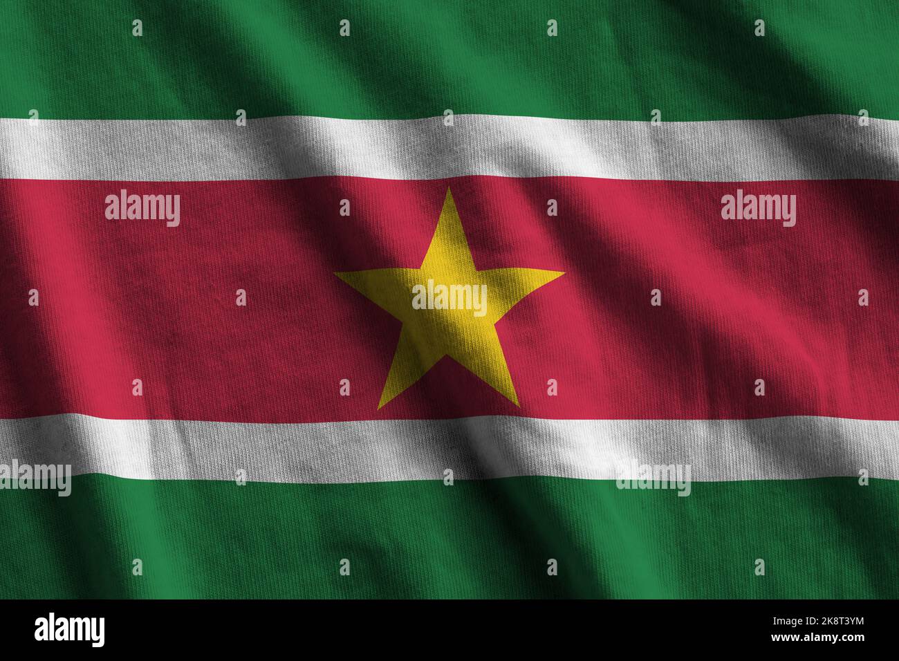 Suriname flag with big folds waving close up under the studio light ...