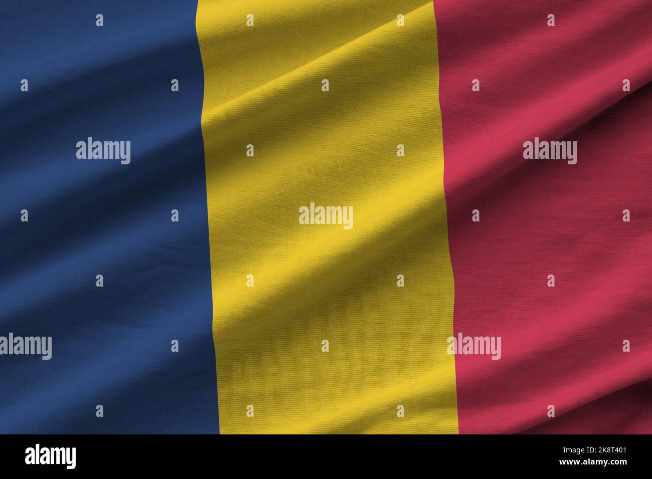 Chad flag with big folds waving close up under the studio light indoors ...