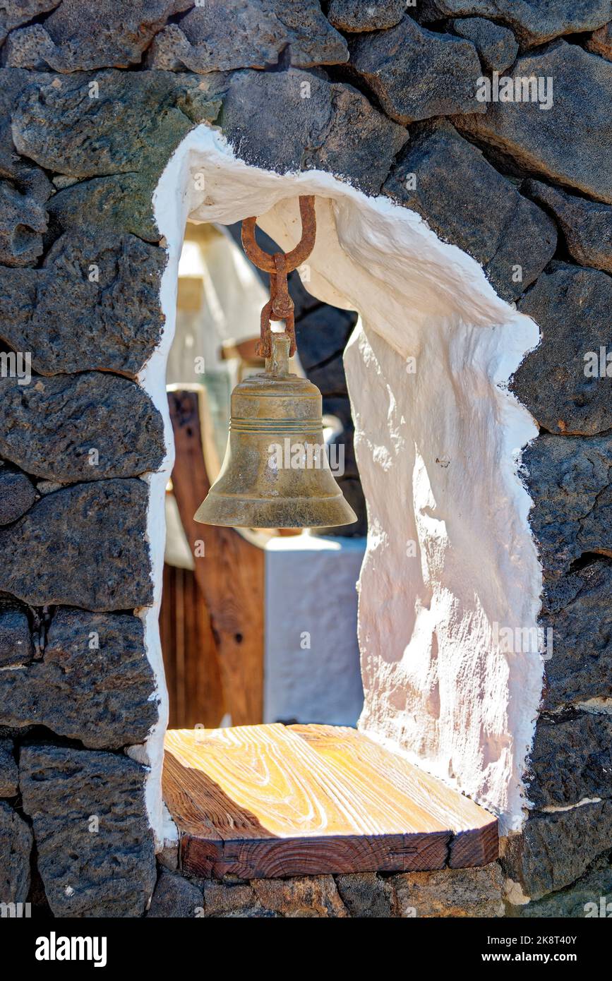 Old bell in a volcanic rock wall in Lanzarote - Spain. Vintage display ...
