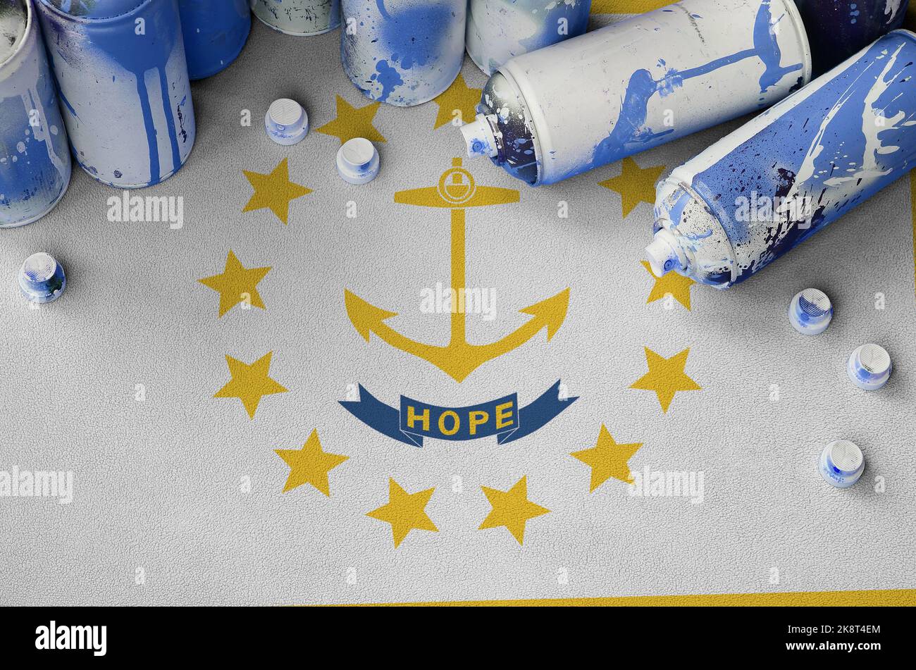 Rhode Island US state flag and few used aerosol spray cans for graffiti ...
