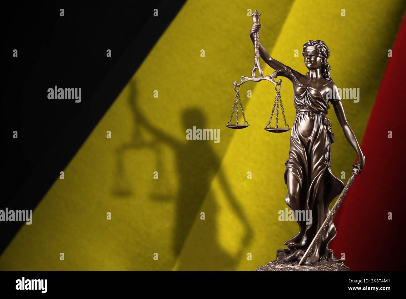 Belgium flag with statue of lady justice and judicial scales in dark ...