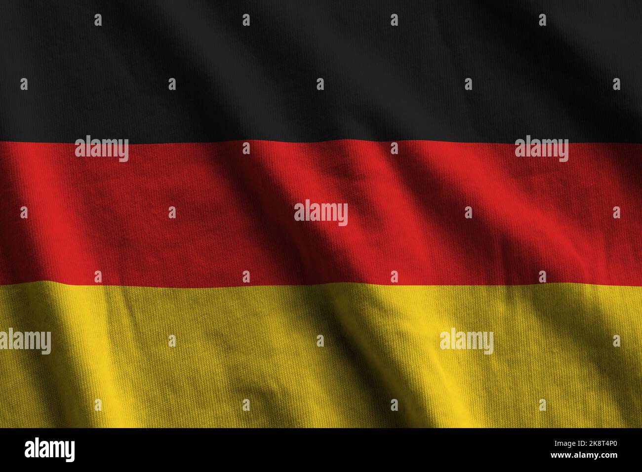 Germany flag with big folds waving close up under the studio light ...