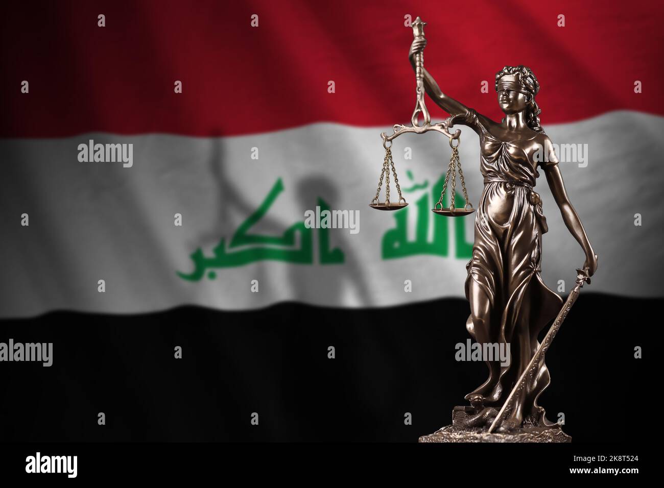 Iraq flag with statue of lady justice and judicial scales in dark room ...