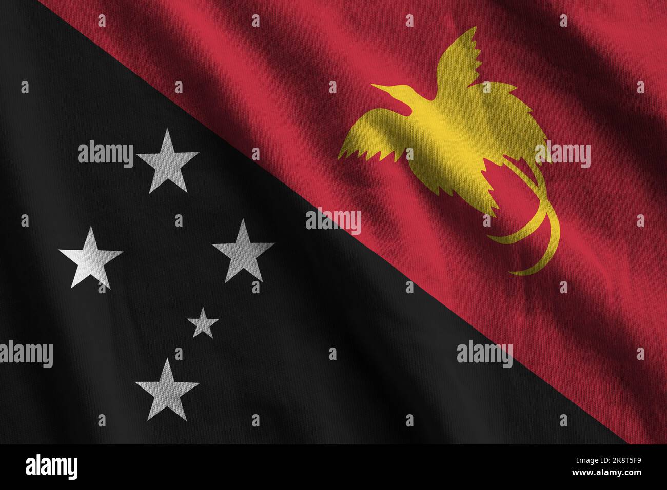 Papua New Guinea flag with big folds waving close up under the studio ...