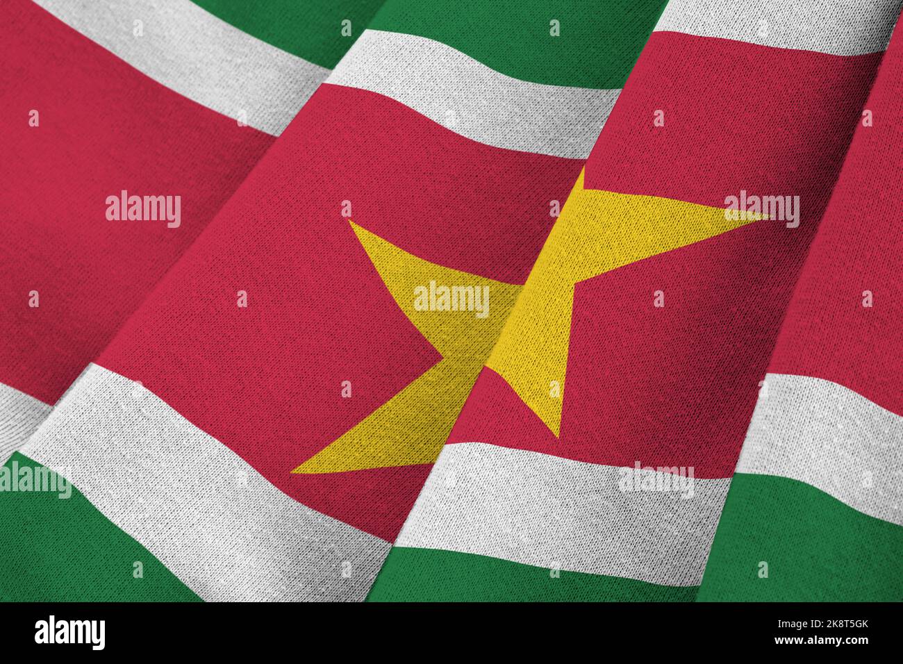 Suriname flag with big folds waving close up under the studio light ...
