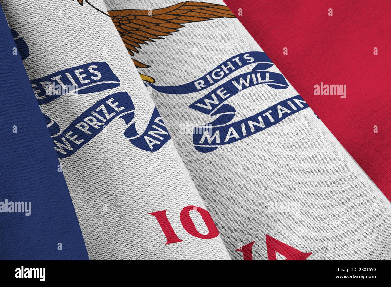 Iowa US state flag with big folds waving close up under the studio ...