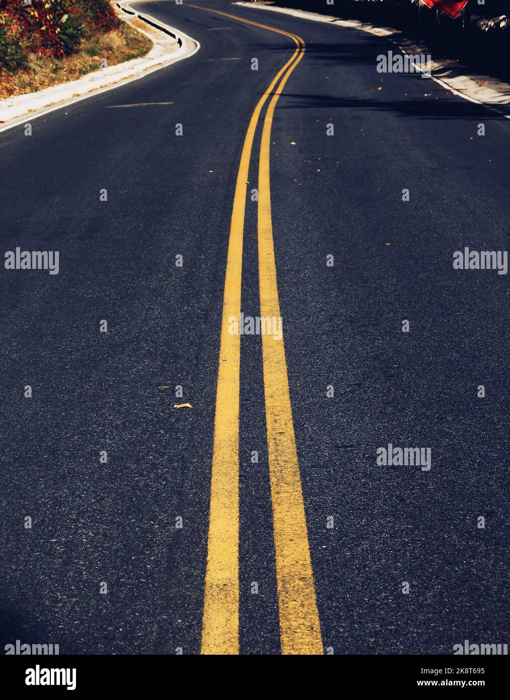 A vertical closeup shot of yellow road lines on the asphalt Stock Photo ...