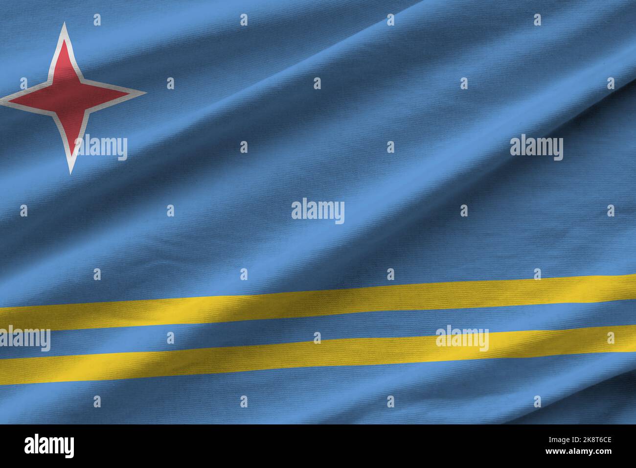 Aruba flag with big folds waving close up under the studio light ...