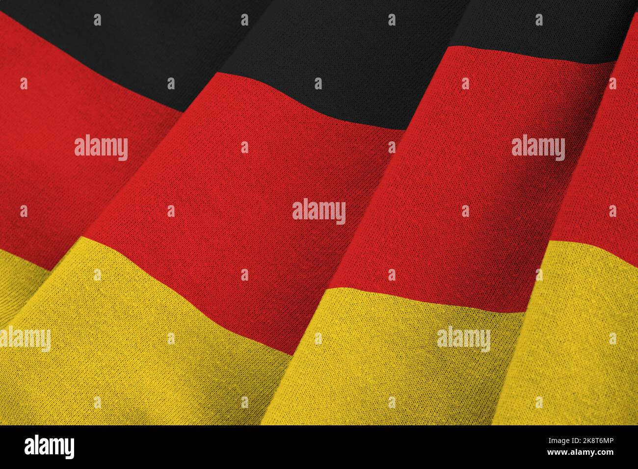 Germany flag with big folds waving close up under the studio light ...