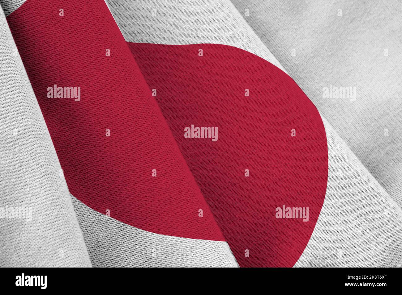 Japan flag with big folds waving close up under the studio light ...