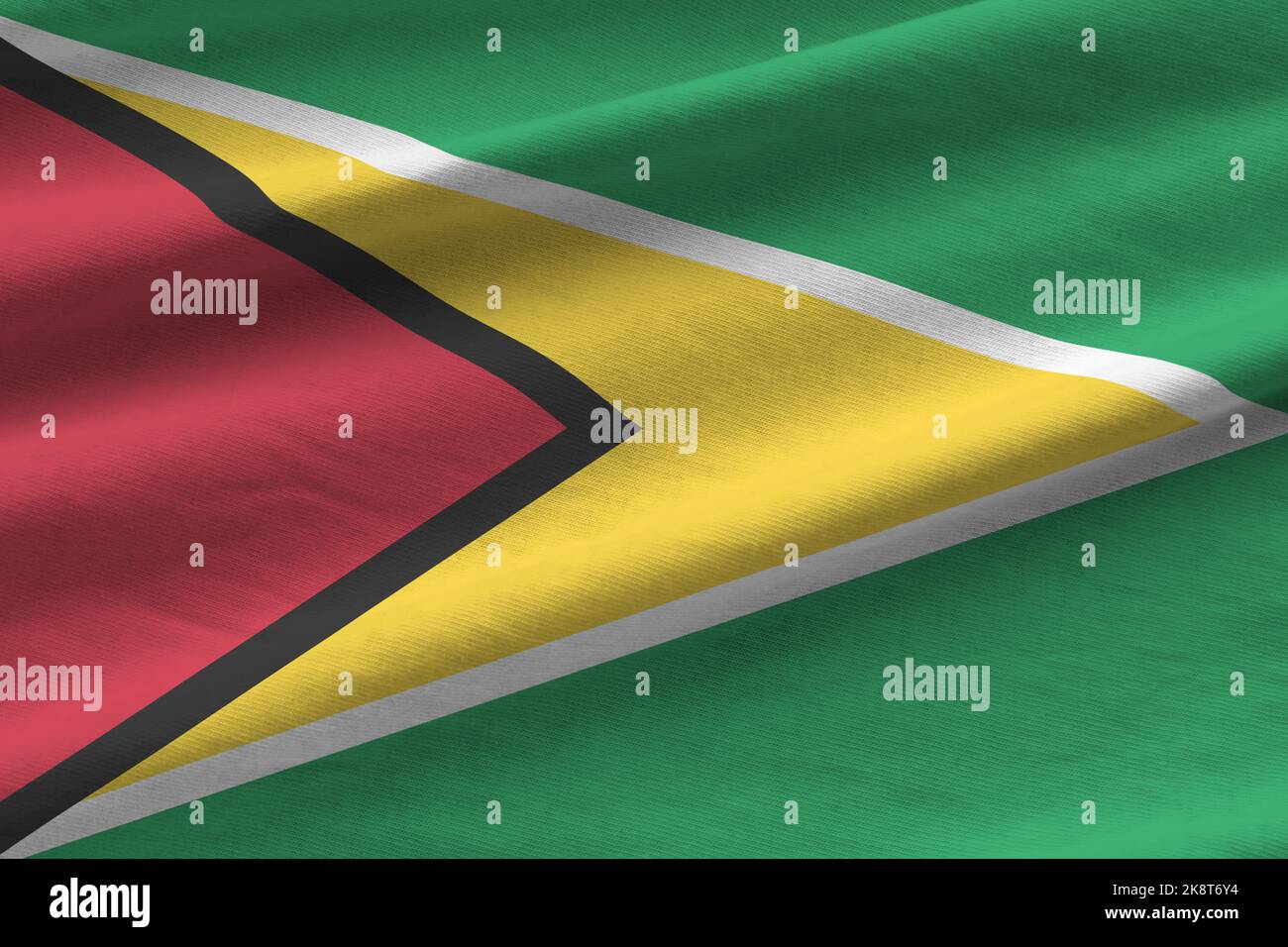 Guyana flag with big folds waving close up under the studio light indoors. The official symbols ...