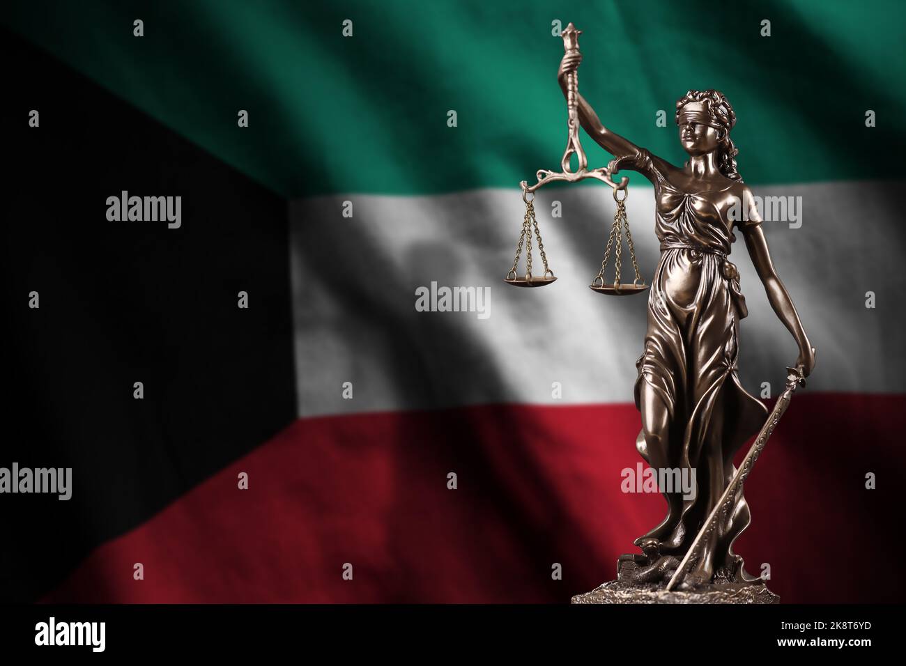 Kuwait flag with statue of lady justice and judicial scales in dark ...