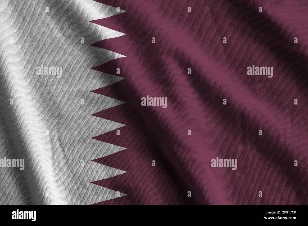 Qatar flag with big folds waving close up under the studio light ...