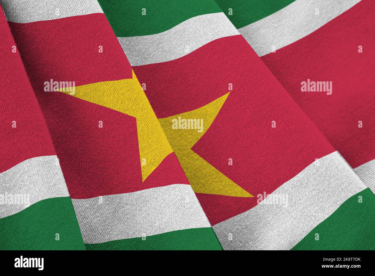 Suriname flag with big folds waving close up under the studio light ...