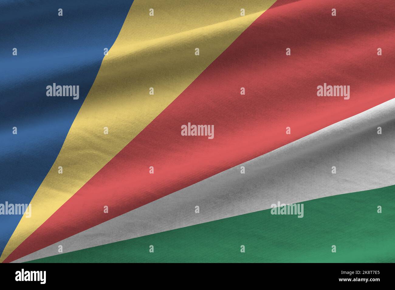 Seychelles flag with big folds waving close up under the studio light ...