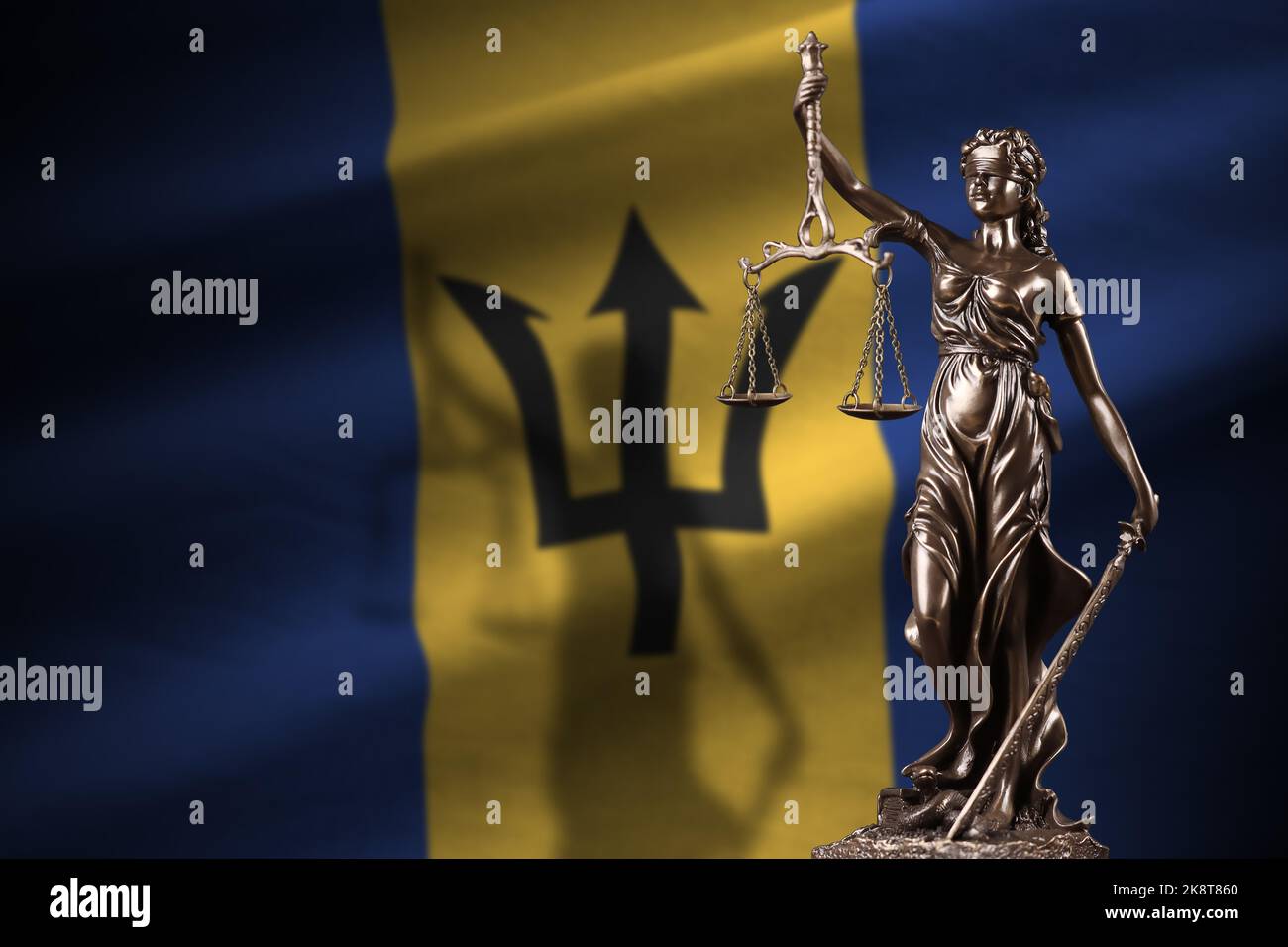 Barbados flag with statue of lady justice and judicial scales in dark ...