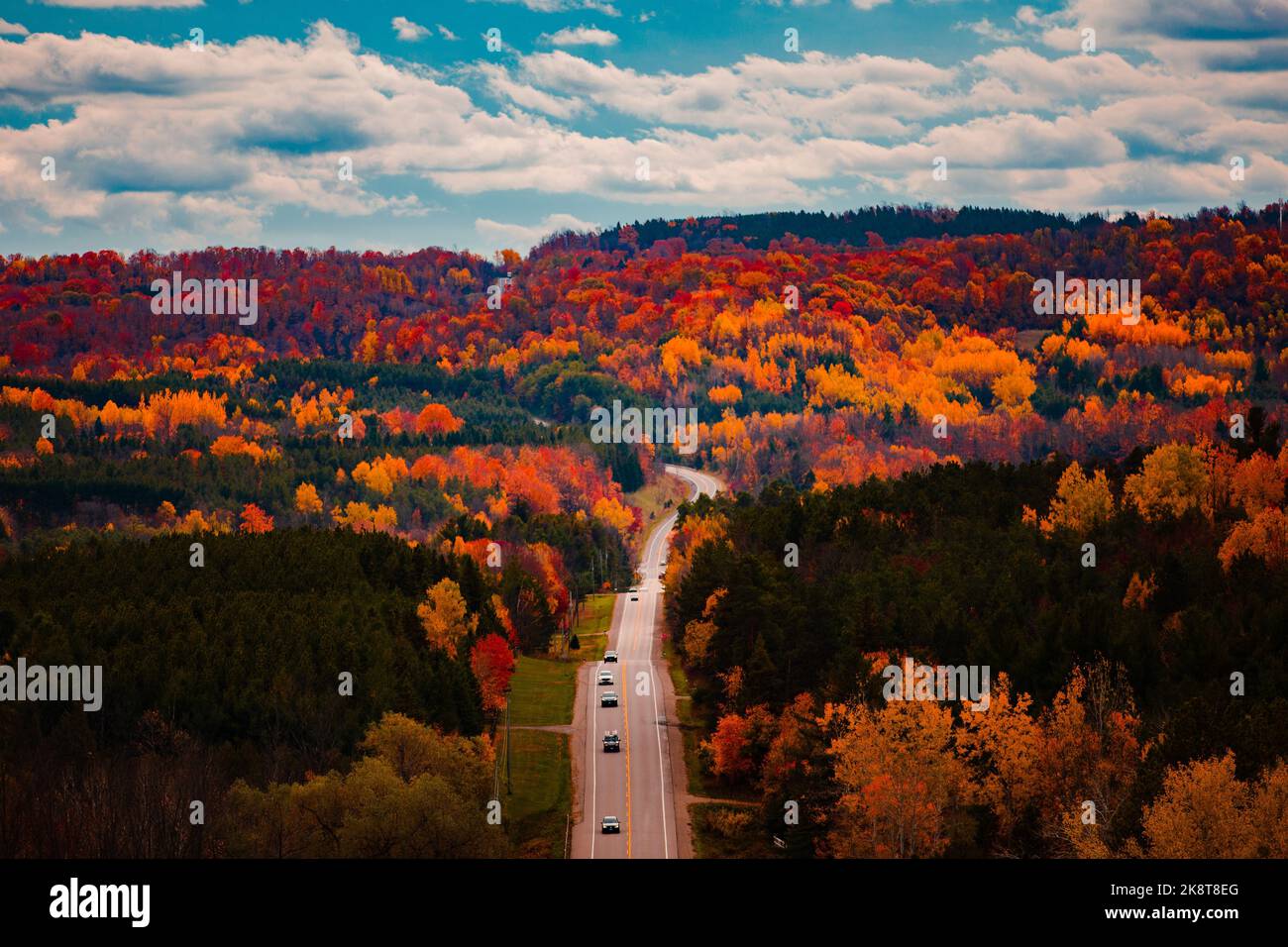 A aerial drone view of winding road passing through the dense ...