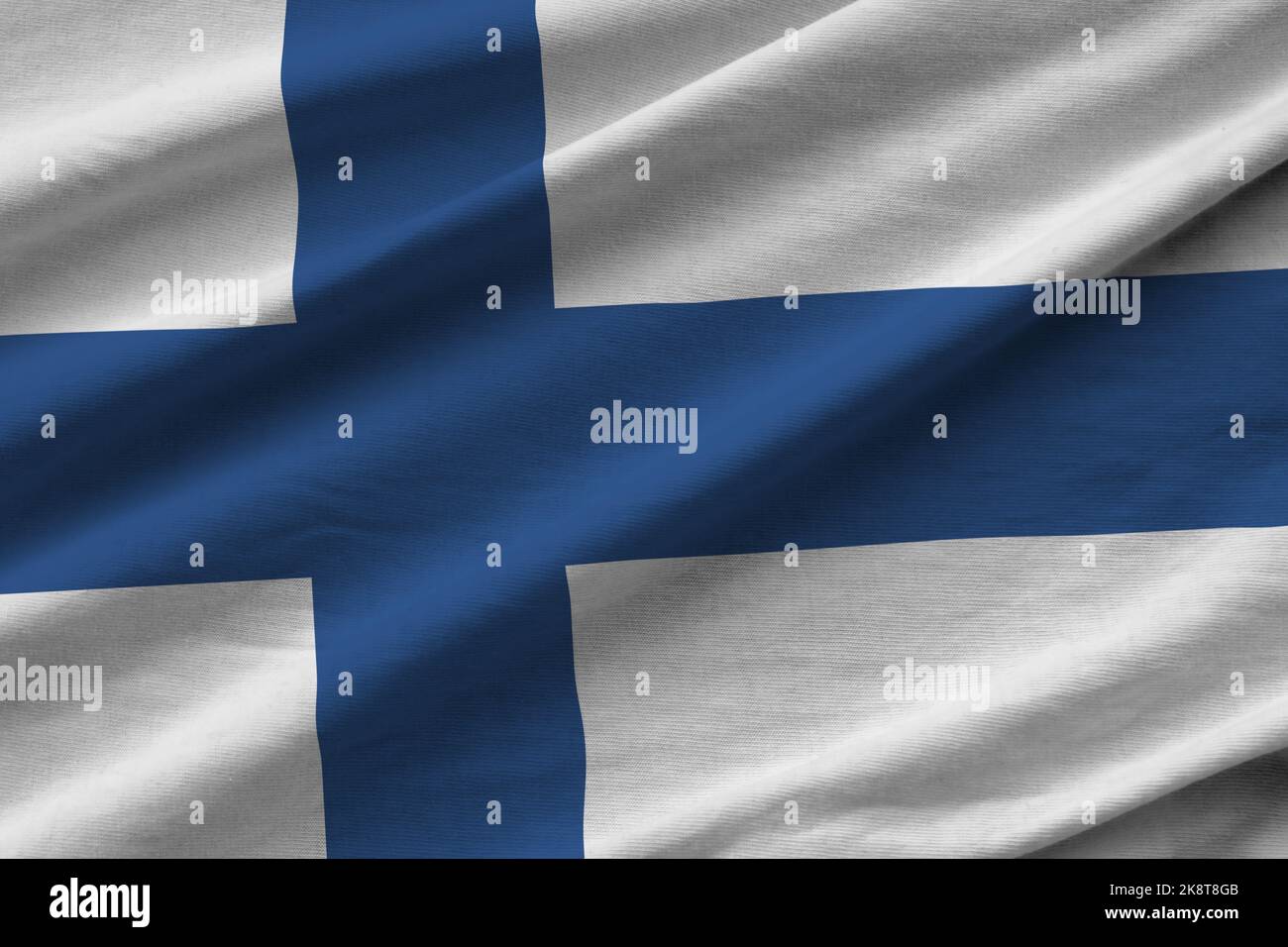 Finland flag with big folds waving close up under the studio light ...