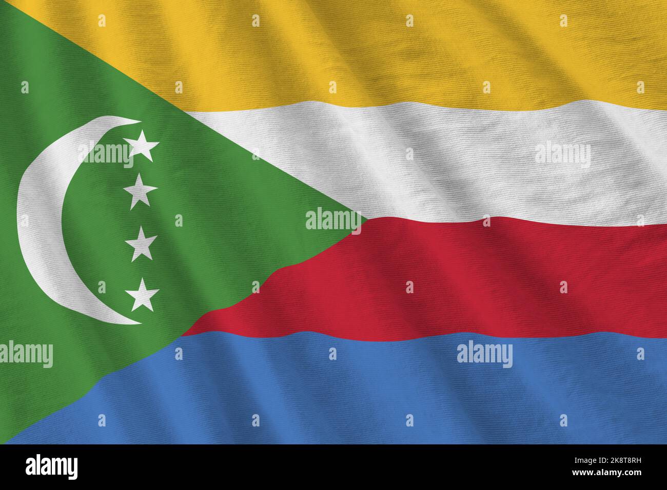 Comoros flag with big folds waving close up under the studio light ...