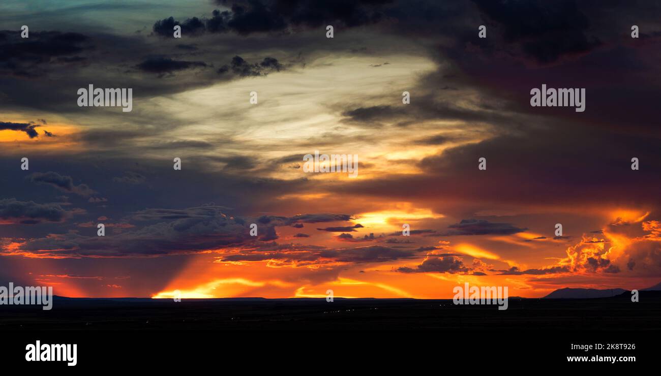 Beautiful sunset cloudscape with bright orange and yellow clouds in blue sky in Arizona ...