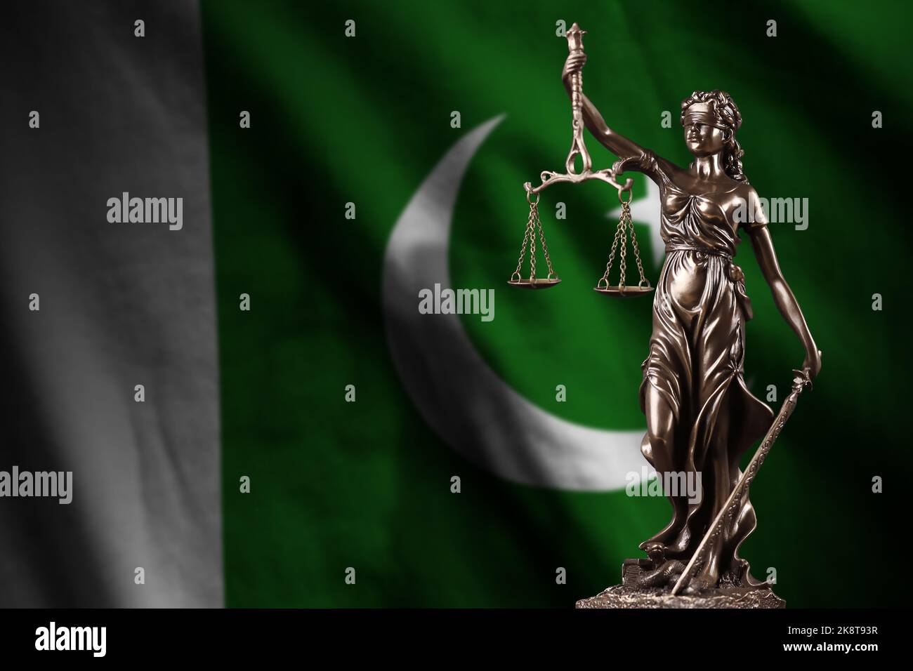 Pakistan flag with statue of lady justice and judicial scales in dark ...