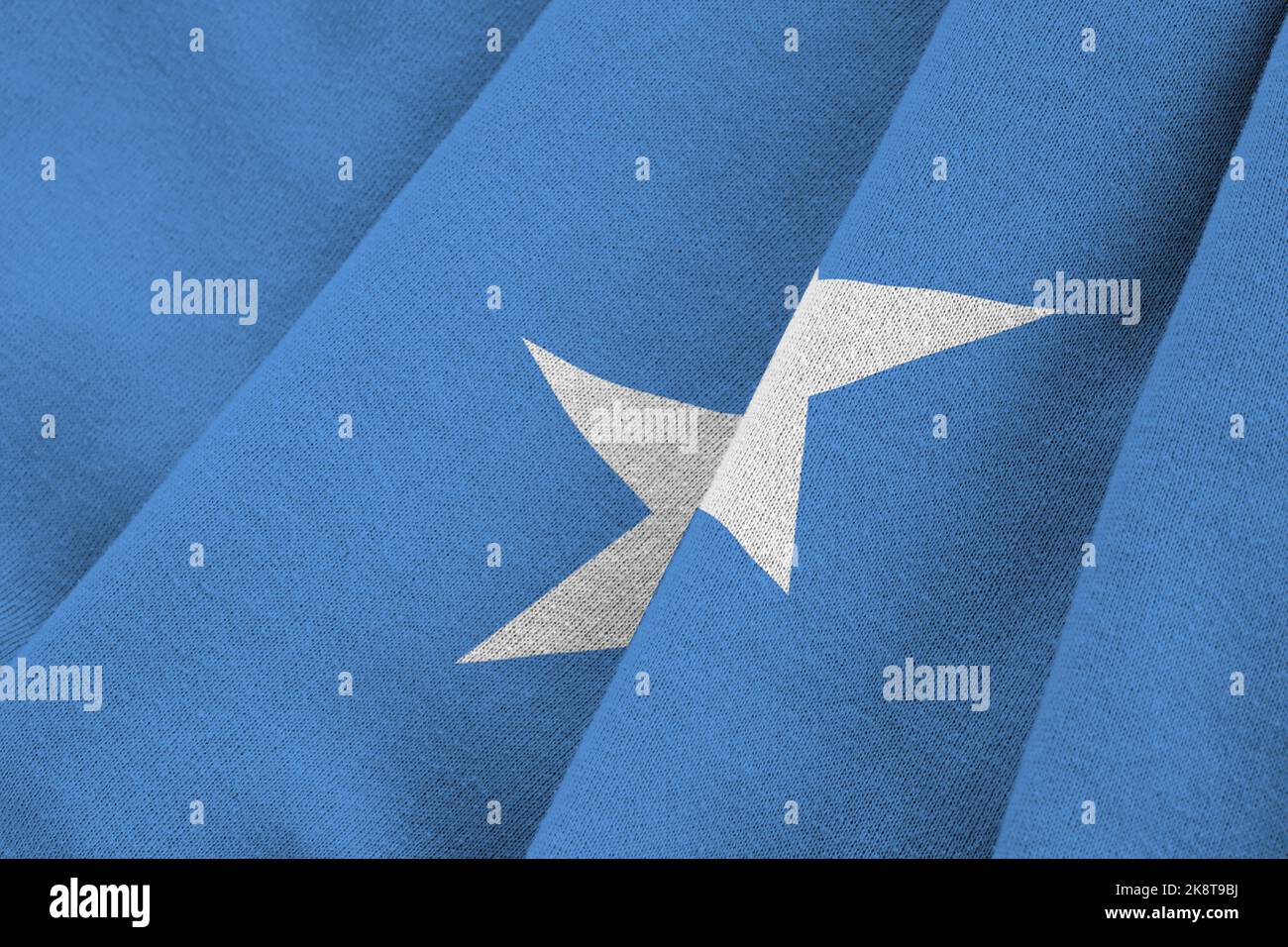 Somalia flag with big folds waving close up under the studio light ...