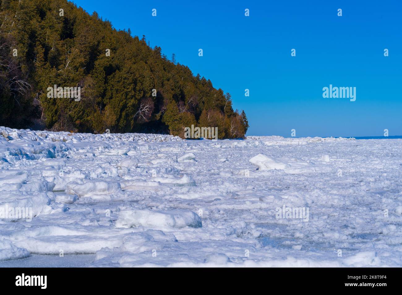 A beautiful shot of a frozen lake covered with snow and a mountain in ...