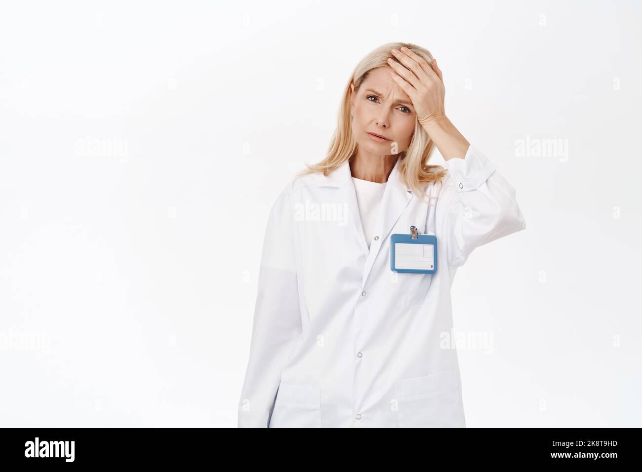 Portrait of tired senior woman doctor, having headache, touching ...