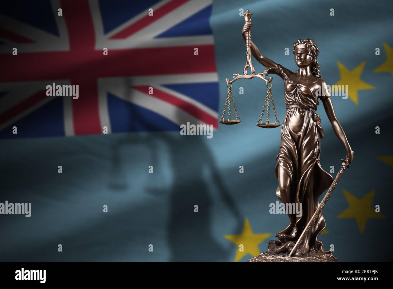 Tuvalu flag with statue of lady justice and judicial scales in dark ...