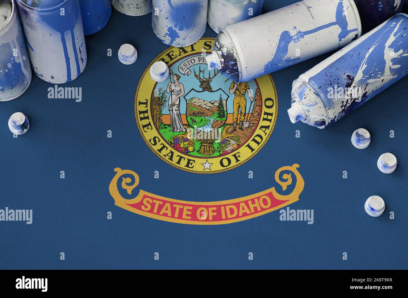 Idaho US state flag and few used aerosol spray cans for graffiti ...
