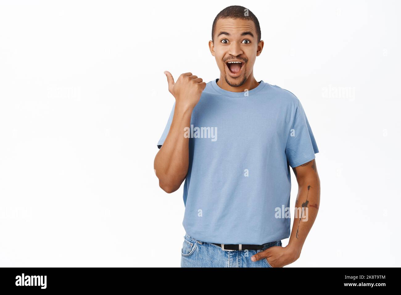 Handsome arab man pointing finger left, showing advertisement and ...