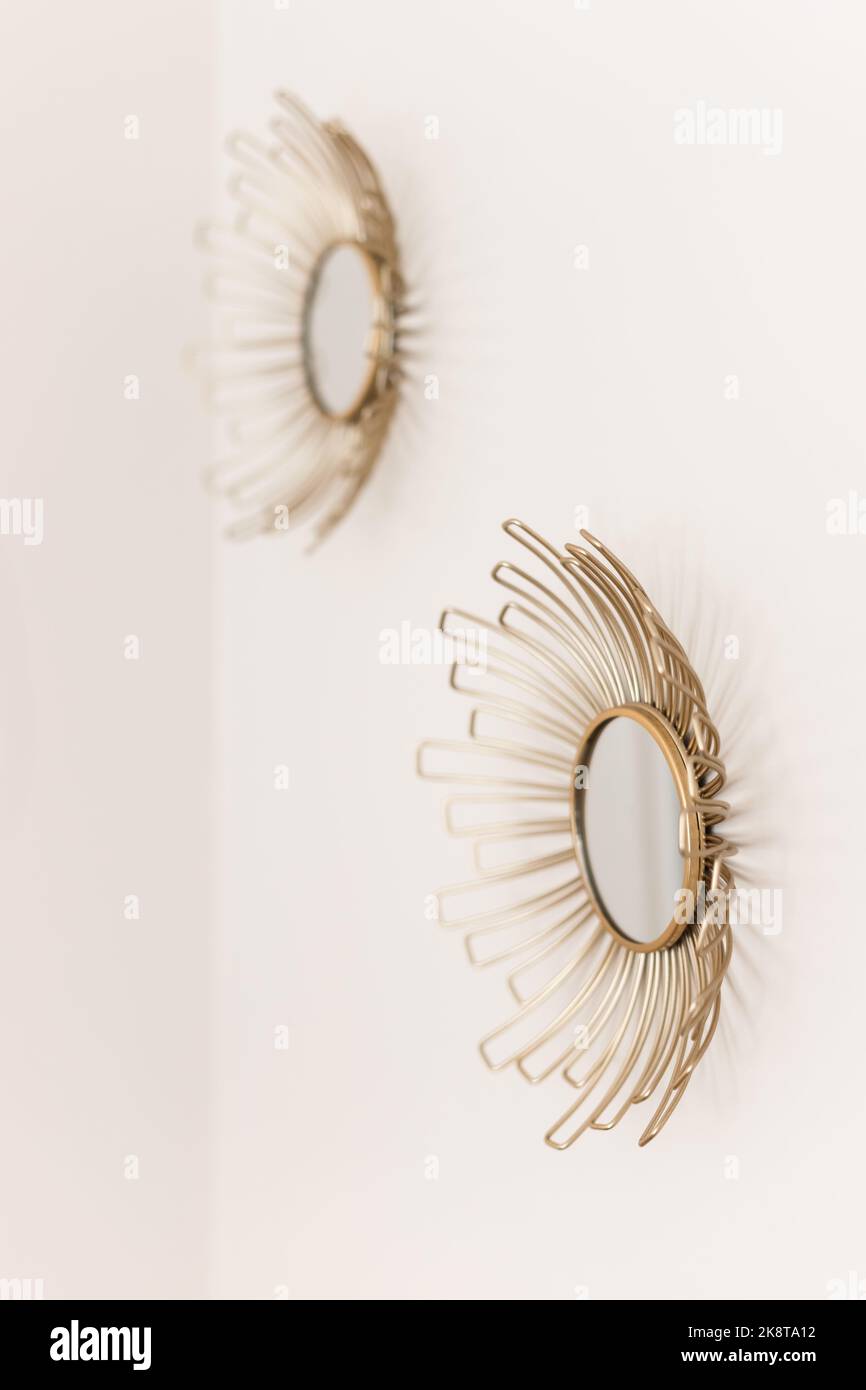 A white wall with two beautiful round gold sun mirrors Stock Photo - Alamy