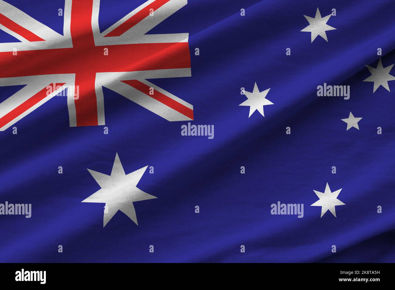 Australia flag with big folds waving close up under the studio light ...