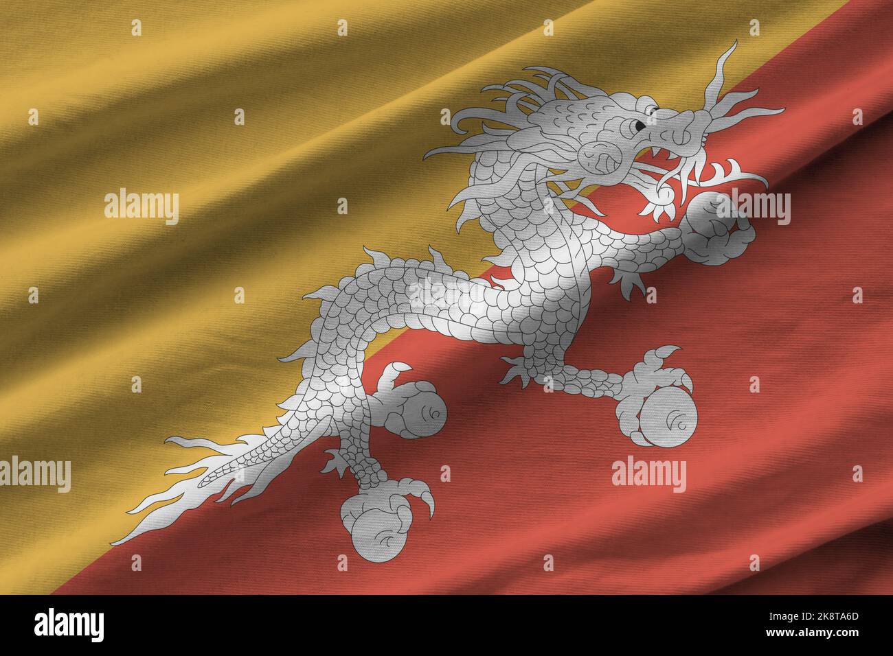 Bhutan flag with big folds waving close up under the studio light ...