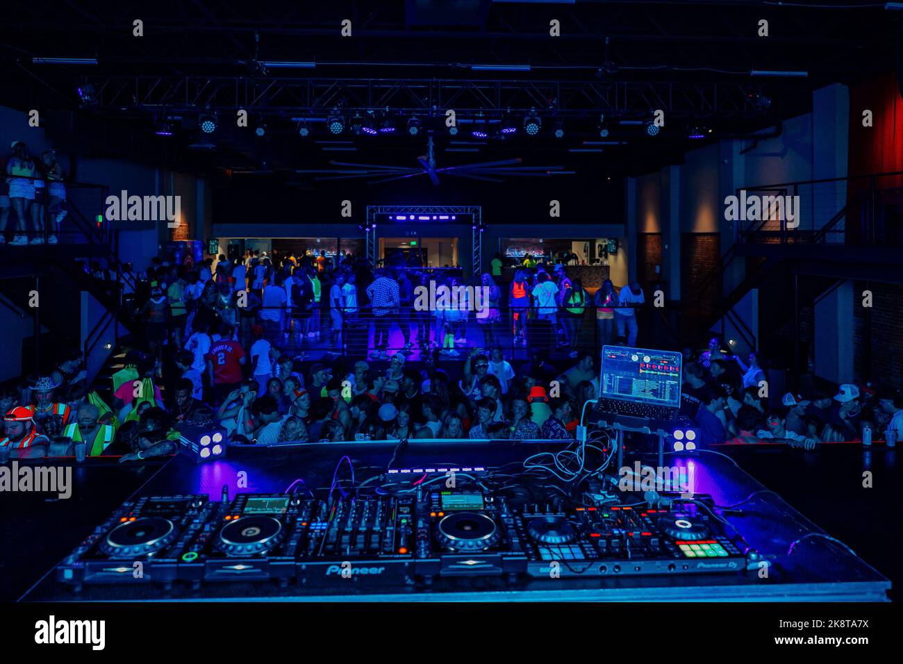 A DJ's equipment with the crowd in the background during music festival ...