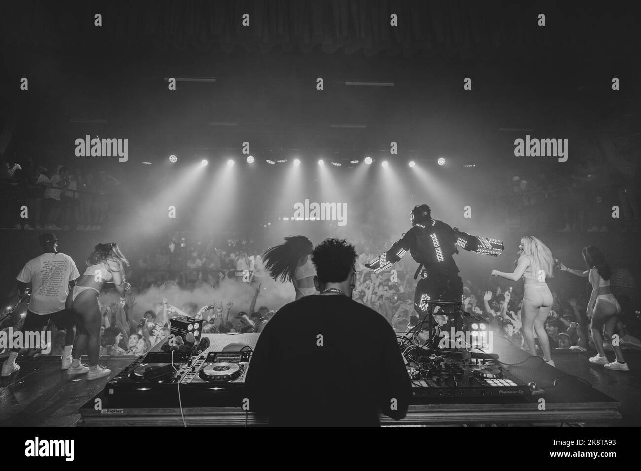 A DJ on the stage during music festival with bright lights in Druid ...