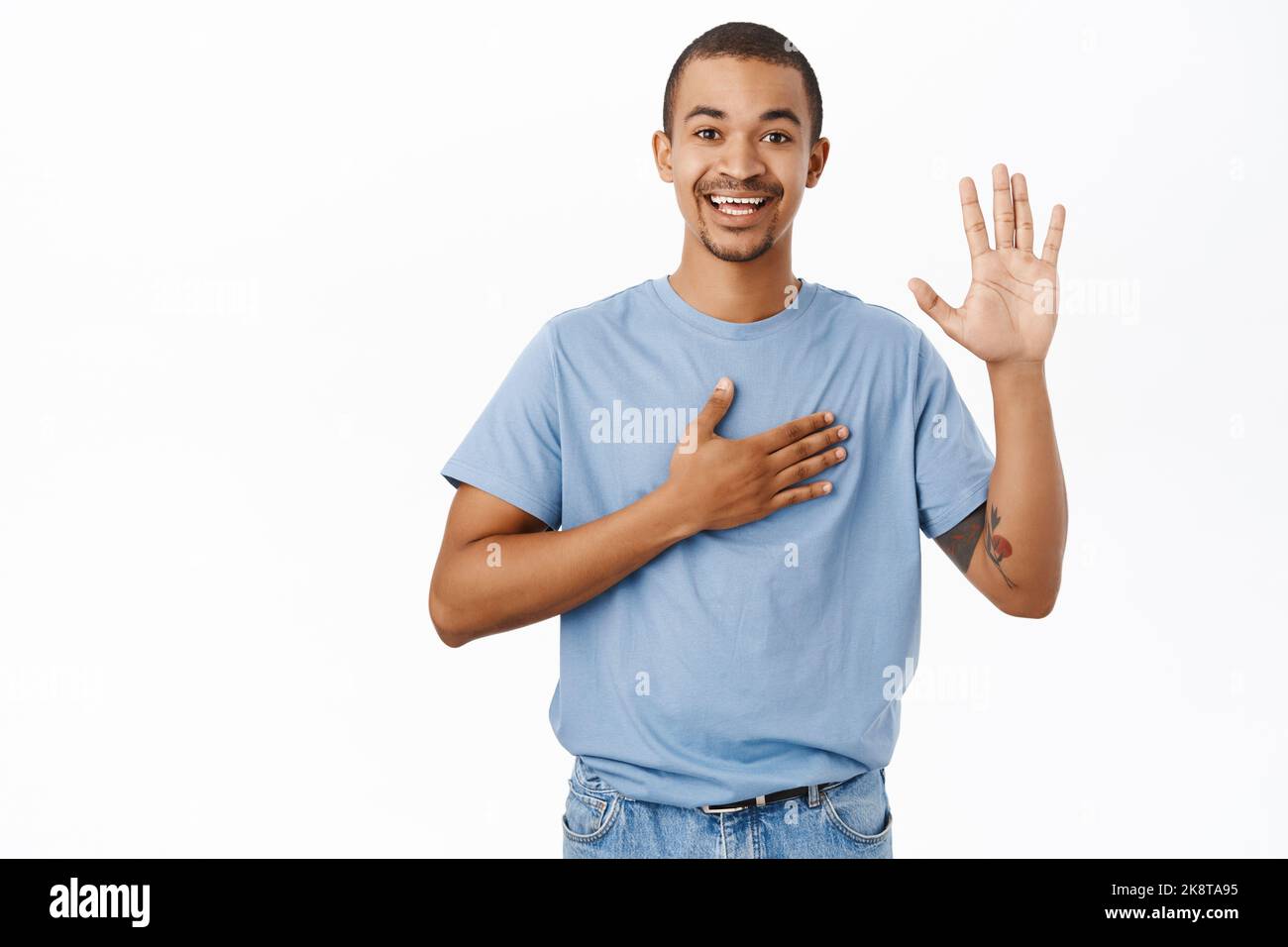 Friendly nice guy raising hand, greeting, introducing himself, waving ...