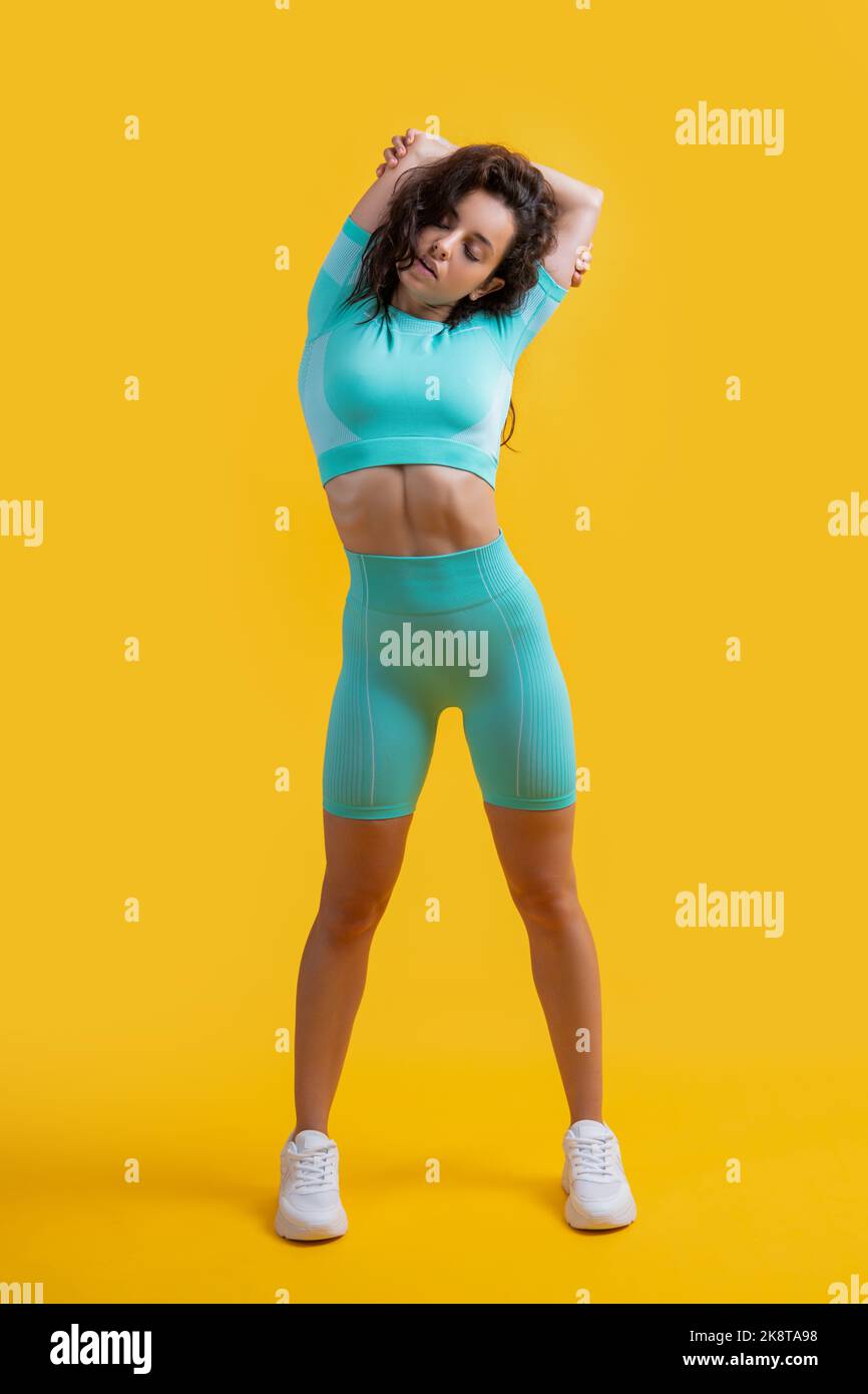 Fit woman doing overhead shoulder stretch exercise studio. Athletic ...